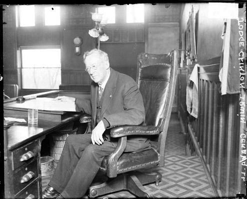 ECC | [Judge Clinton Irwin sitting behind desk in courtroom, Genev