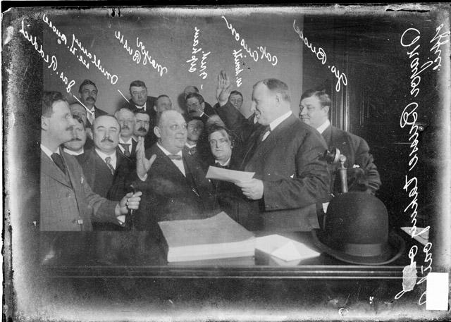ECC | [Mayor Fred A. Busse, surrounded by other men, taking the oa