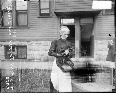 ECC | [Anna Patton and two of her prized cats outside her home, 73