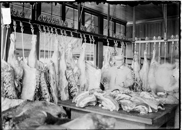 ECC | [Man butchering meat surrounded by animal carcasses hanging