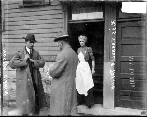 ECC | [Isabella Patton, standing in the doorway of her home, watch