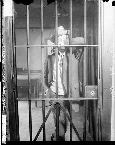 ECC | [Joseph Weil (Yellow Kid) standing behind a door made of iro