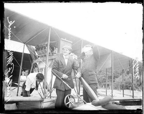 ECC | [Harold F. McCormick, looking up, standing in an airplane wi