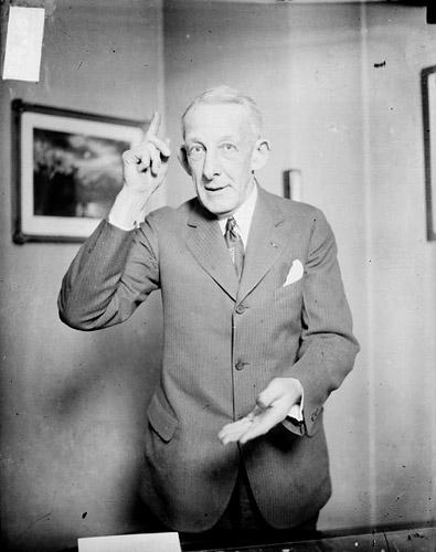 ECC | [Louis L. Emmerson looking toward the camera, holding up his