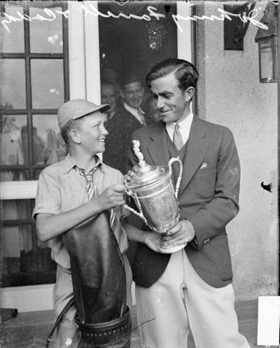ECC | [Golfer, Johnny Farrell and his caddie holding a trophy at a