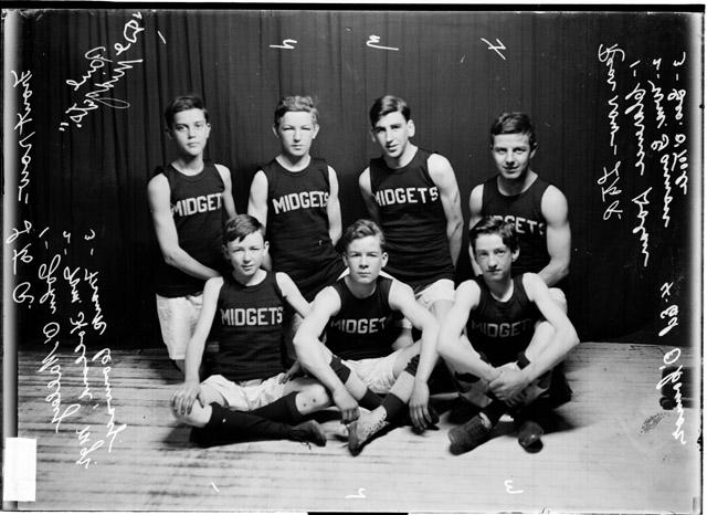 ECC | [DePaul Midgets basketball team posing in front of a dark co