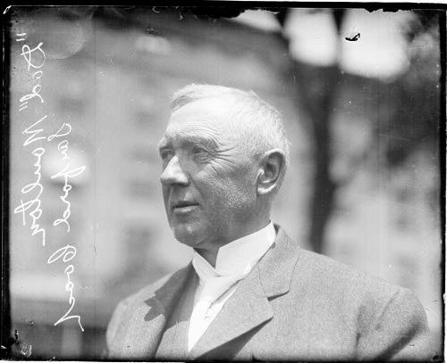 ECC | [Stanford trainer "Dad" Moulton standing in front of a build