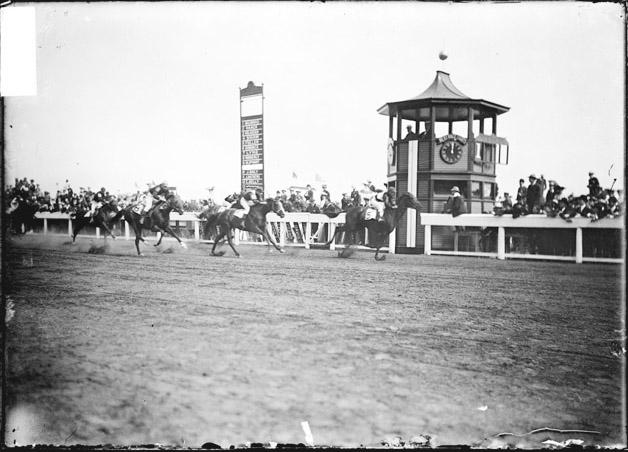 ECC | [Derby Day, racehorses racing on track, passing officials' s