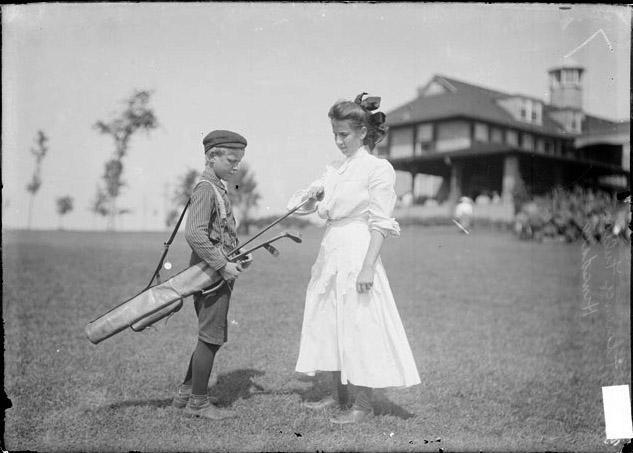 ECC | [Golfer Florence Fulton, selecting a club from her golf bag,