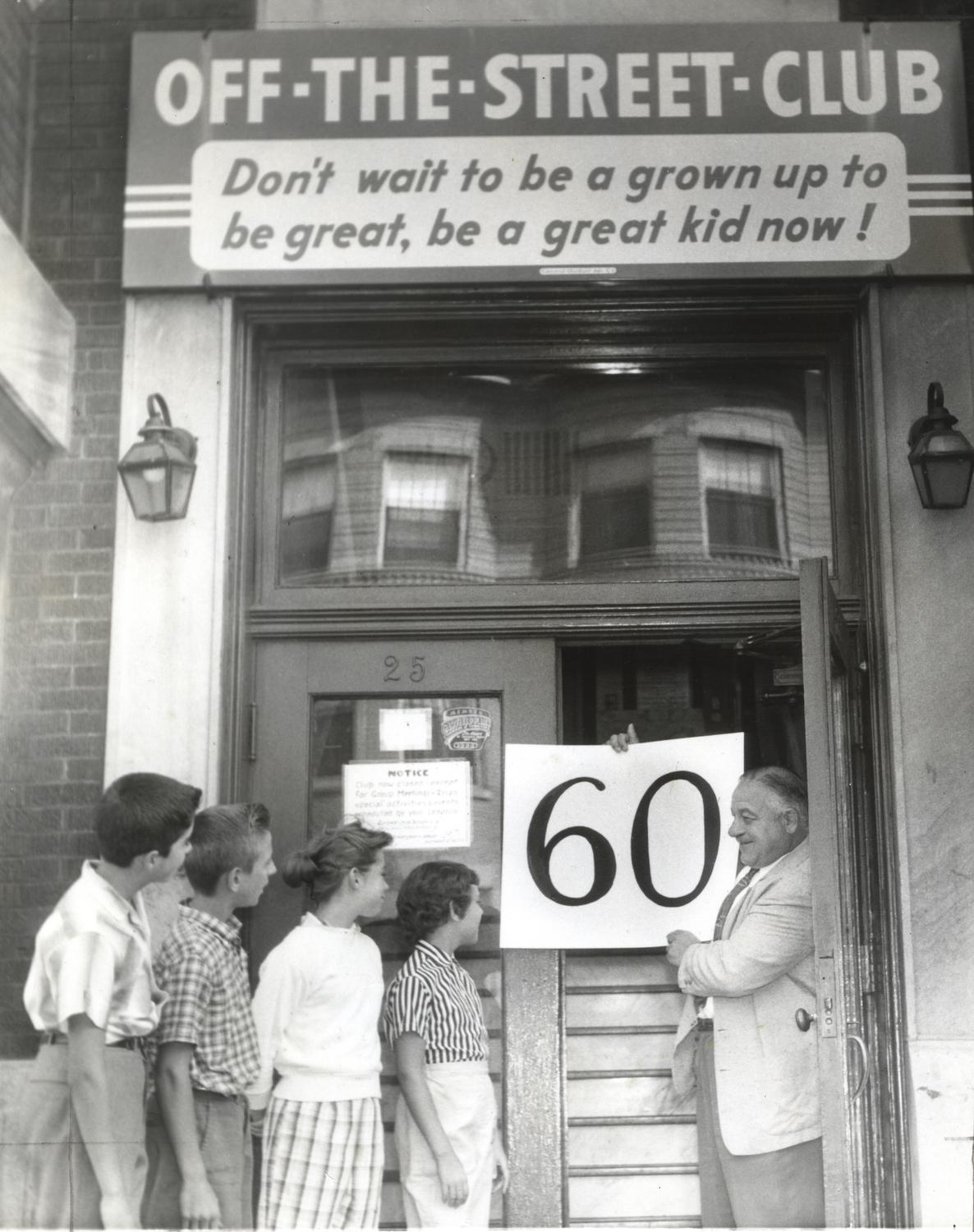 ECC | Four children lined up looking at a sign of "60"